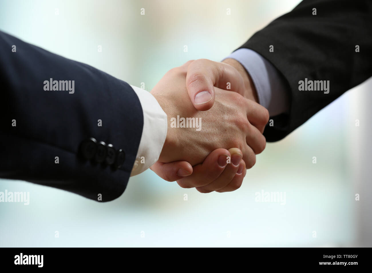 Business handshake on bright background Stock Photo - Alamy