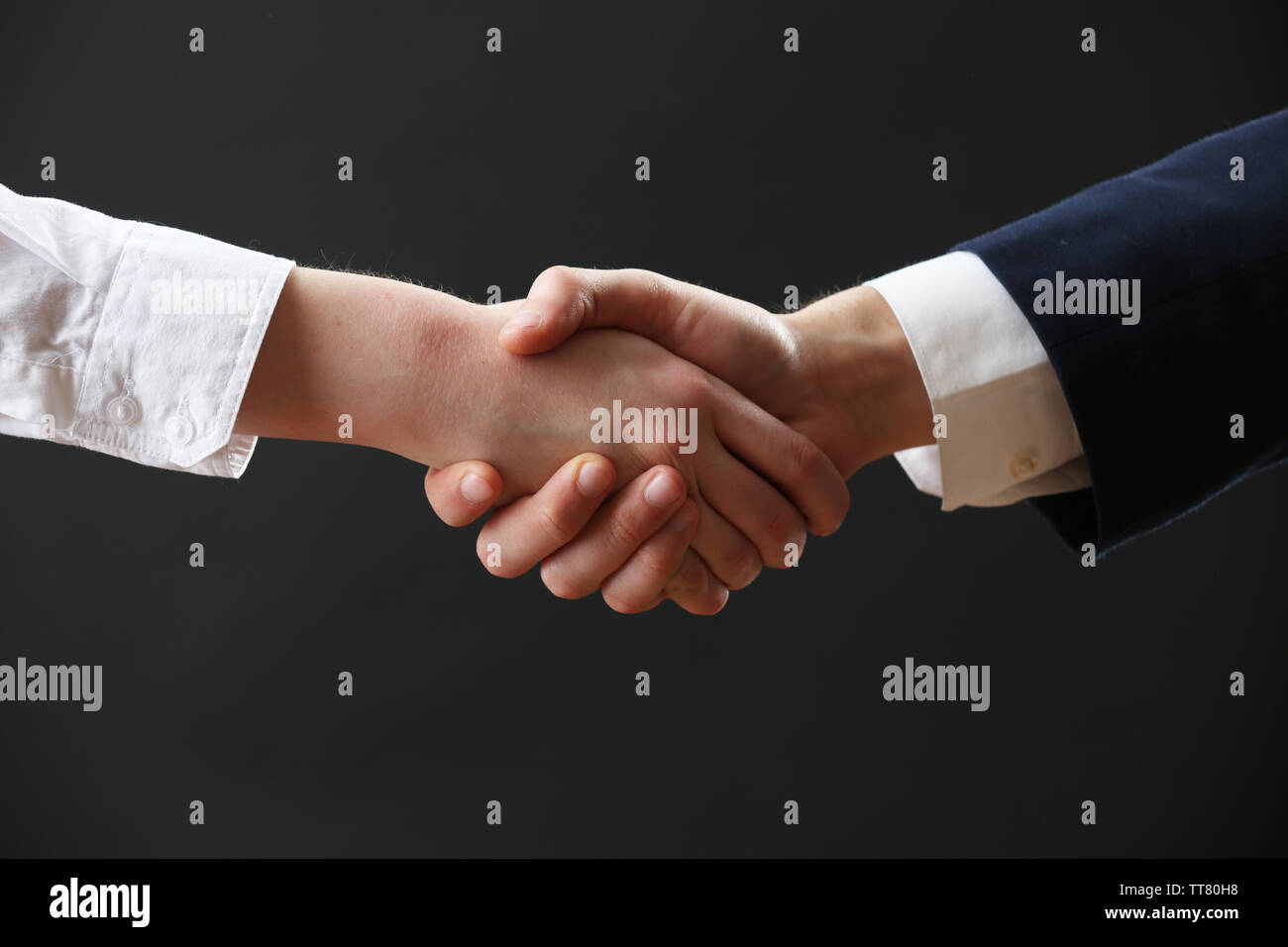 Business handshake on dark background Stock Photo - Alamy