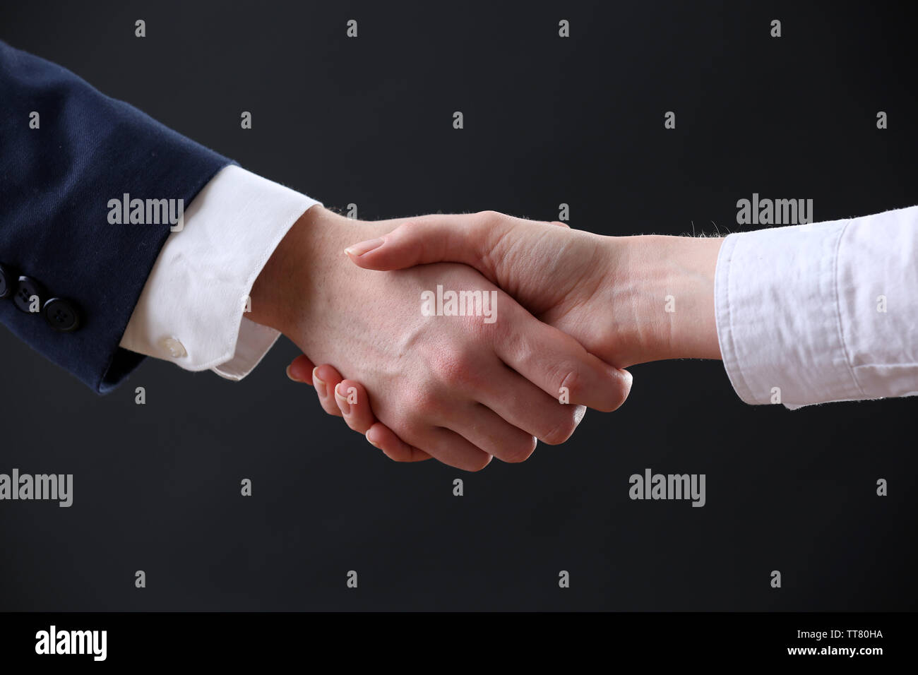 Business handshake on dark background Stock Photo - Alamy