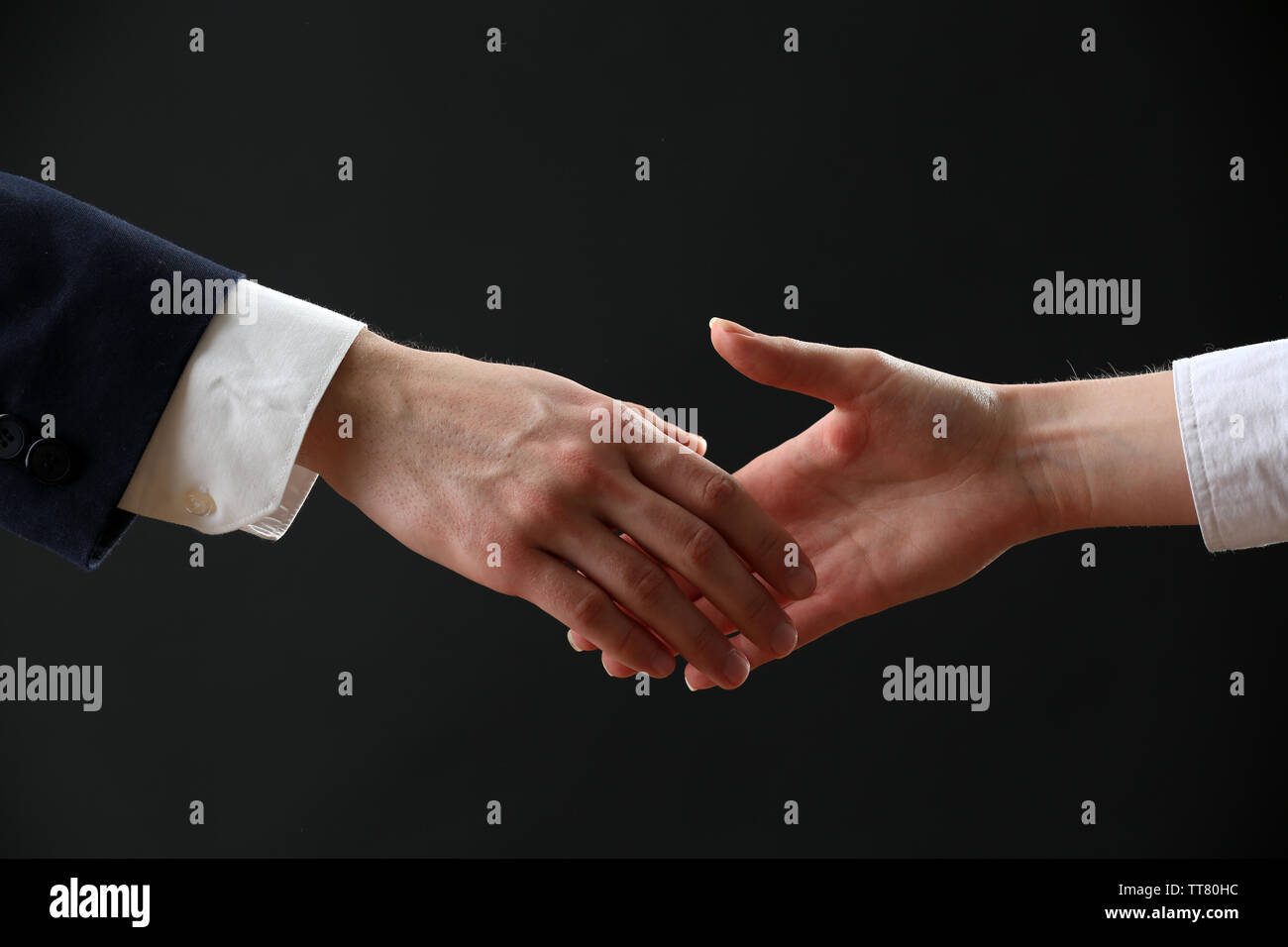 Business handshake on dark background Stock Photo - Alamy