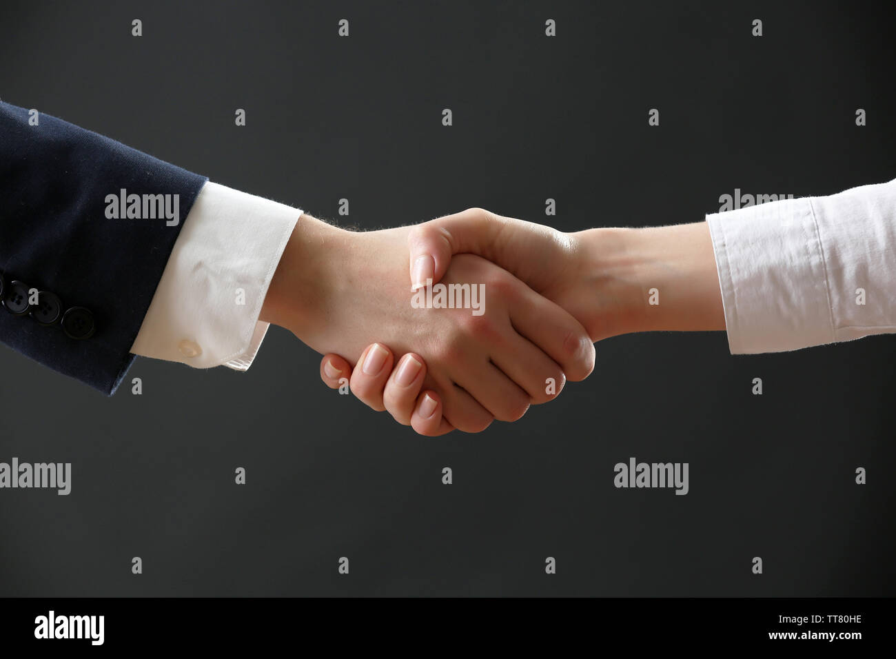 Business handshake on dark background Stock Photo - Alamy