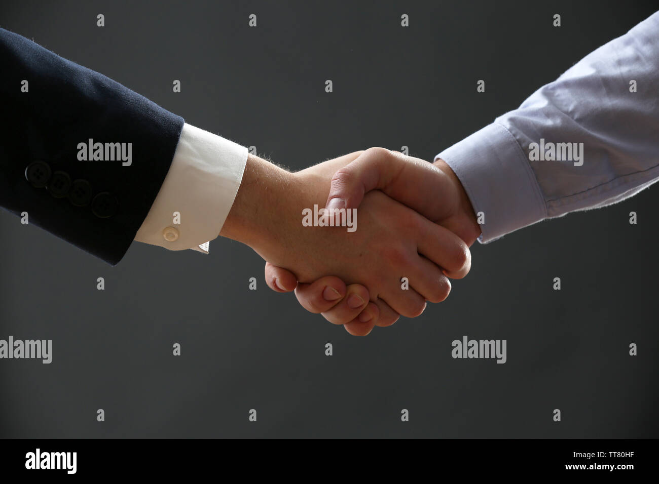 Business handshake on dark background Stock Photo - Alamy