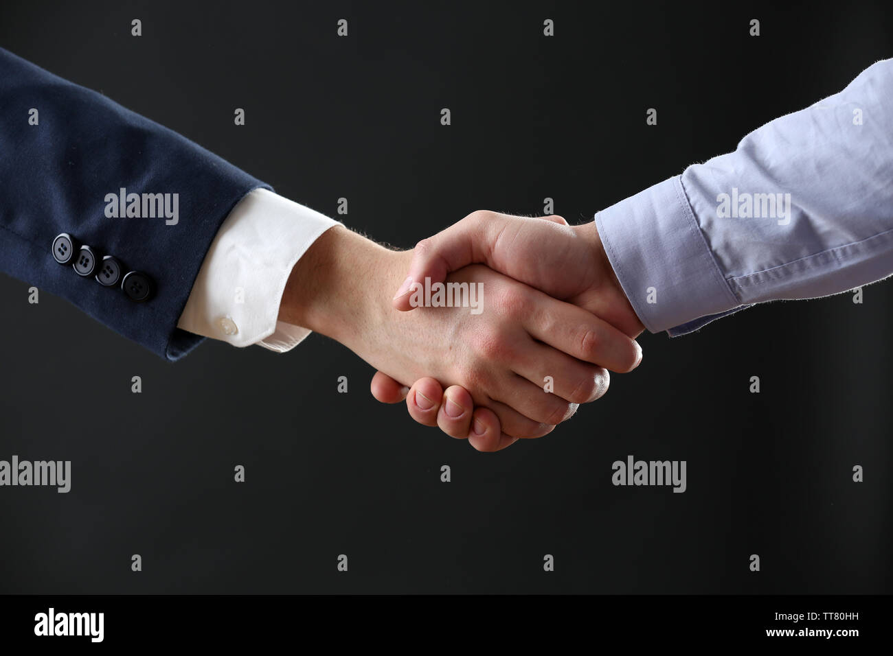 Business handshake on dark background Stock Photo - Alamy
