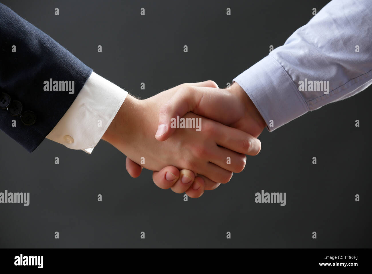 Business handshake on dark background Stock Photo - Alamy