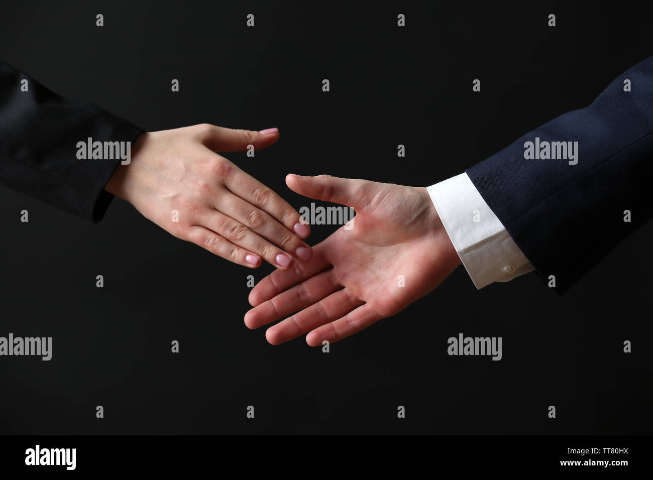 Business handshake on dark background Stock Photo - Alamy
