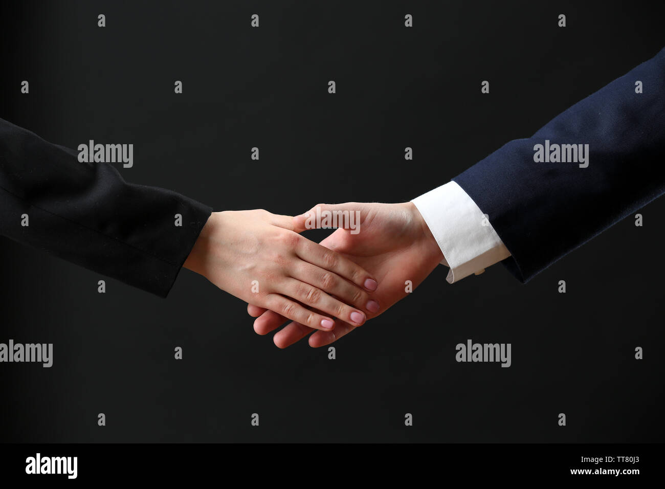 Business handshake on dark background Stock Photo - Alamy