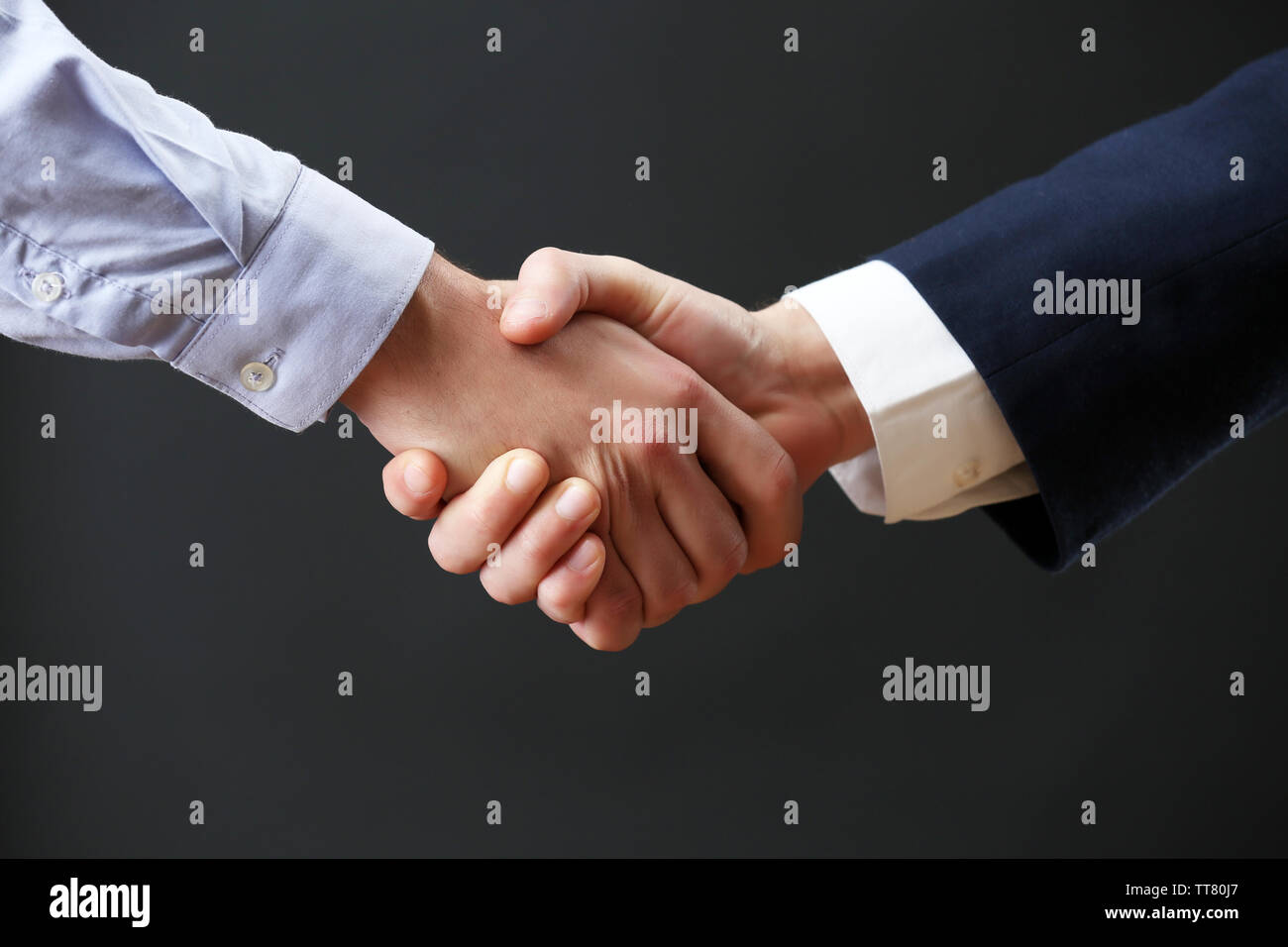 Business handshake on dark background Stock Photo - Alamy