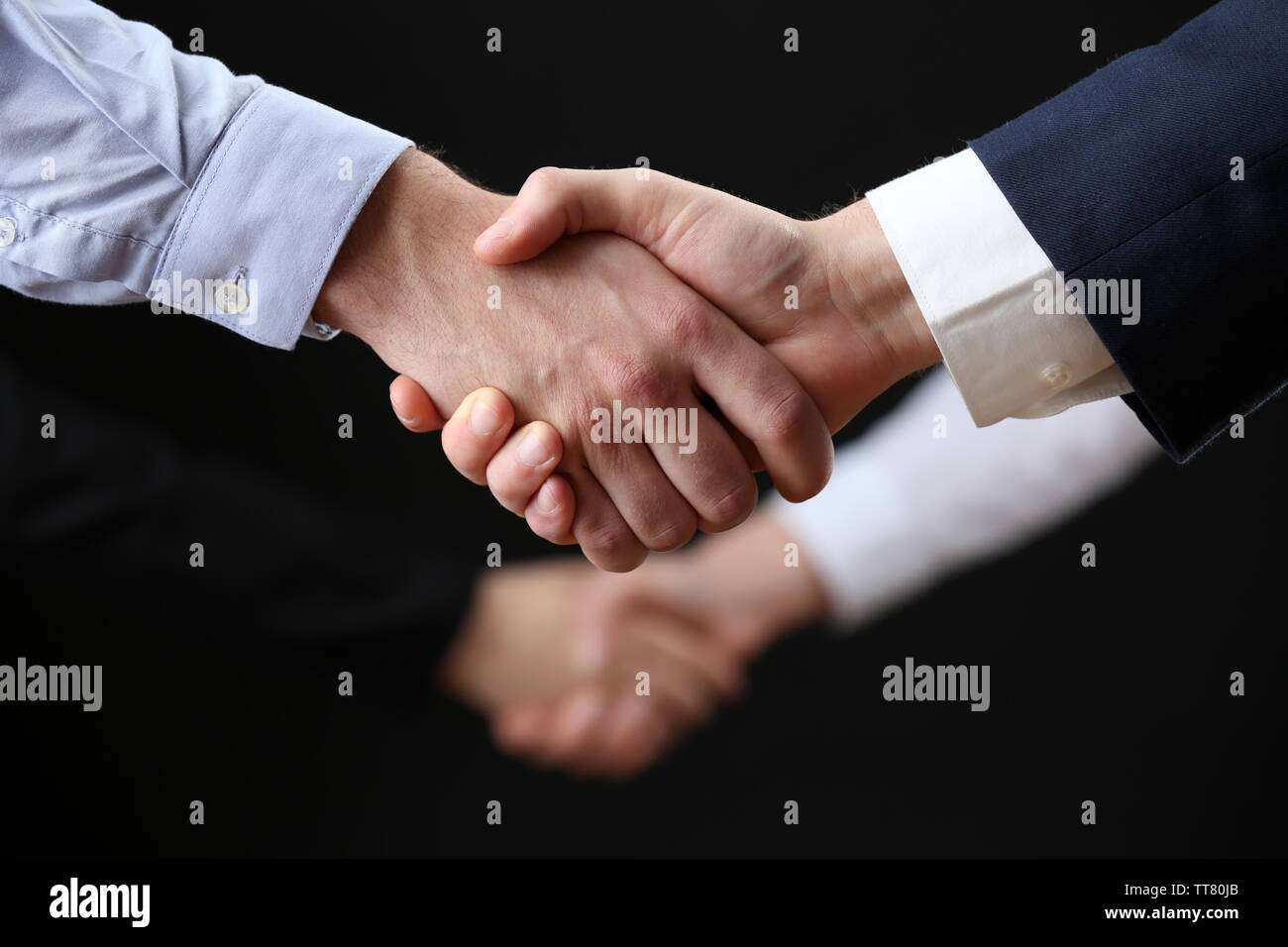 Business handshake on dark background Stock Photo - Alamy