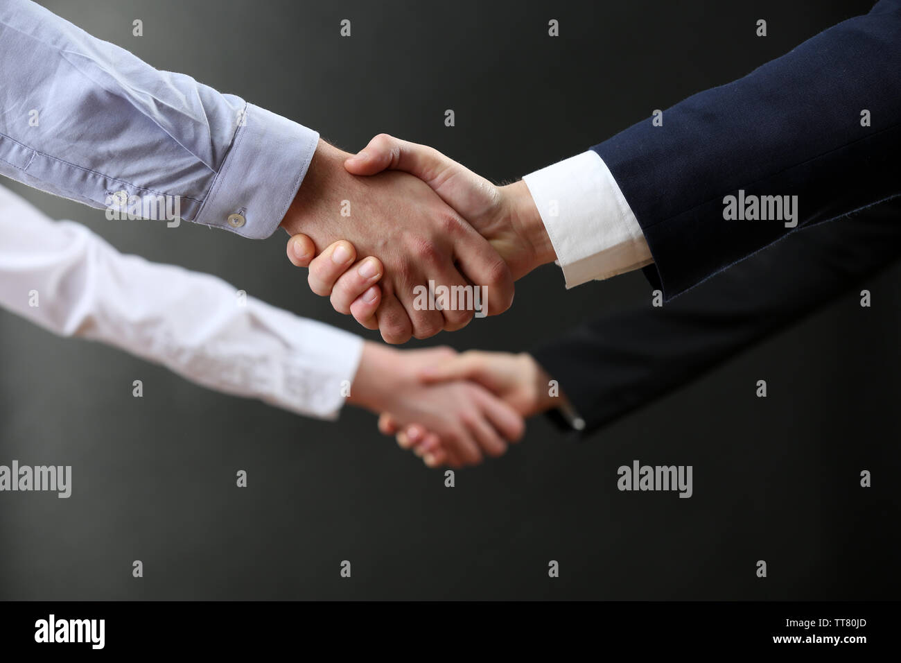 Business handshake on dark background Stock Photo - Alamy
