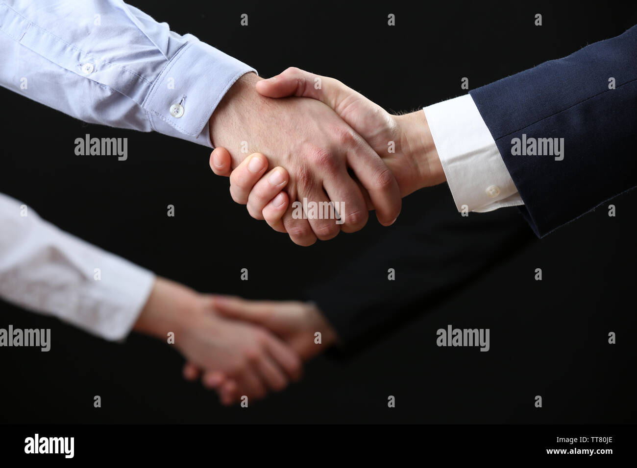 Business handshake on dark background Stock Photo - Alamy