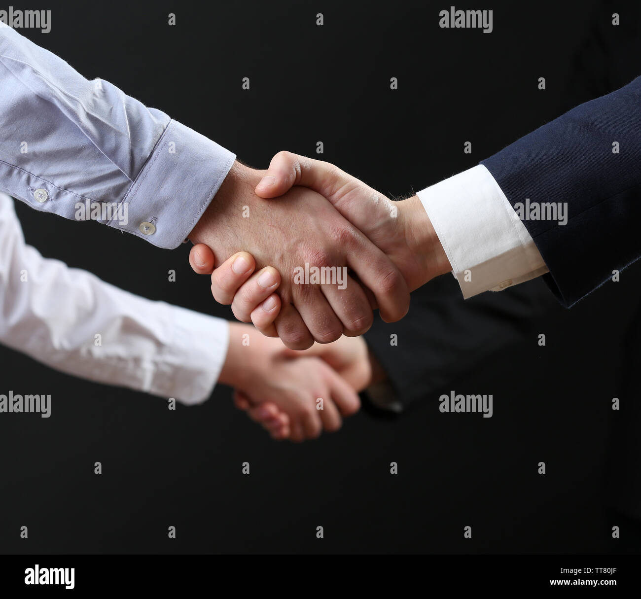 Business handshake on dark background Stock Photo - Alamy