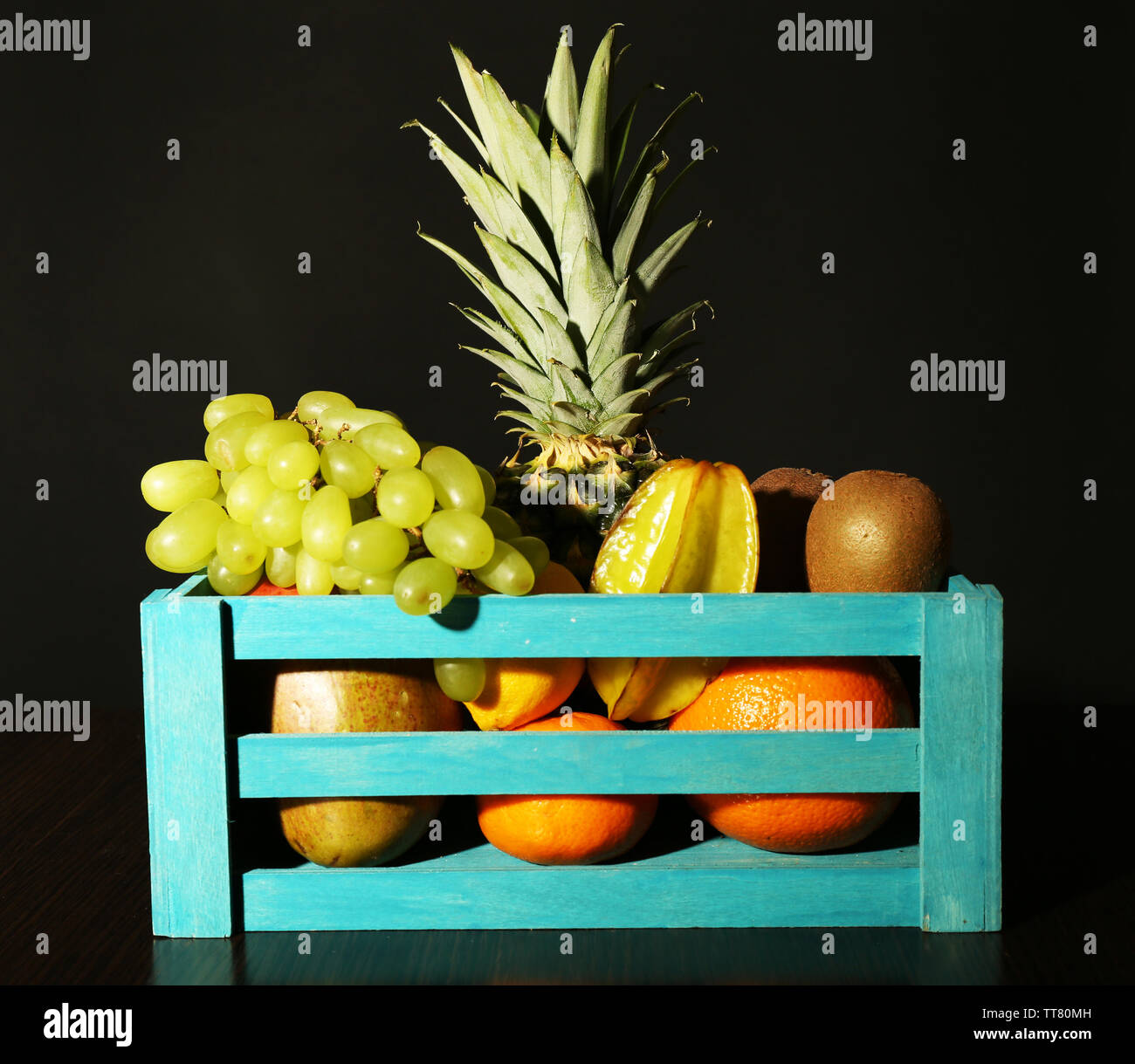 Assortment of fruits in box on dark background Stock Photo - Alamy
