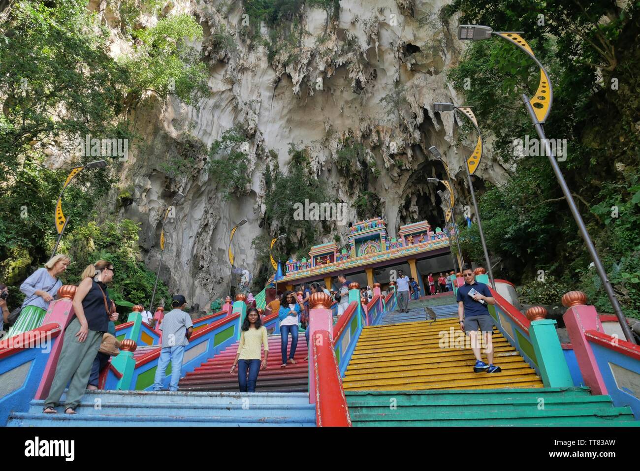 Tourists on ladders in Batu Caves. Batu Caves is a limestone hill that ...