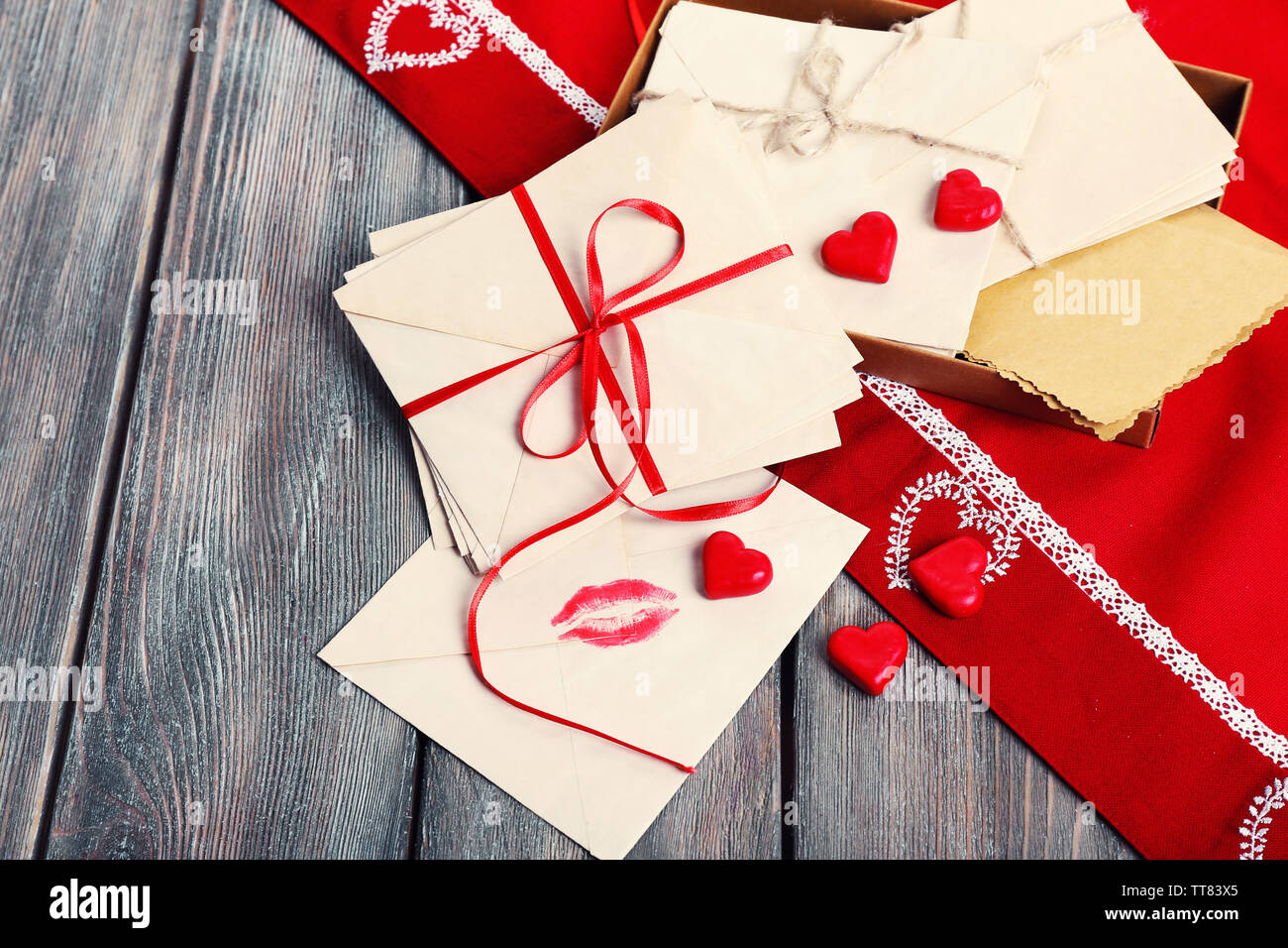 Love letters with red ribbon on wooden background Stock Photo - Alamy