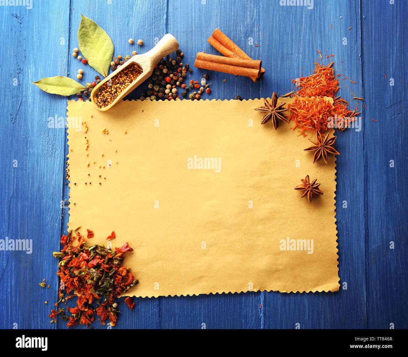 Different kinds of spices on blank paper sheet on wooden background ...
