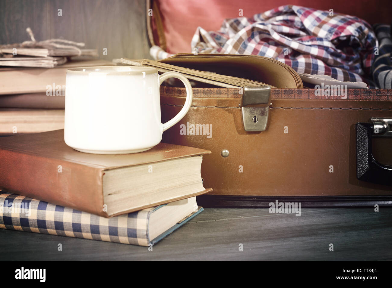 Vintage suitcase open with clothes and books on wooden background Stock ...