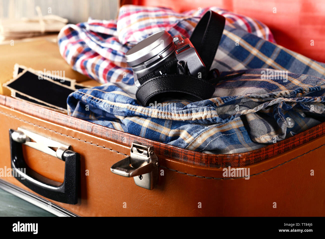 Vintage suitcase open with clothes and books close up Stock Photo - Alamy