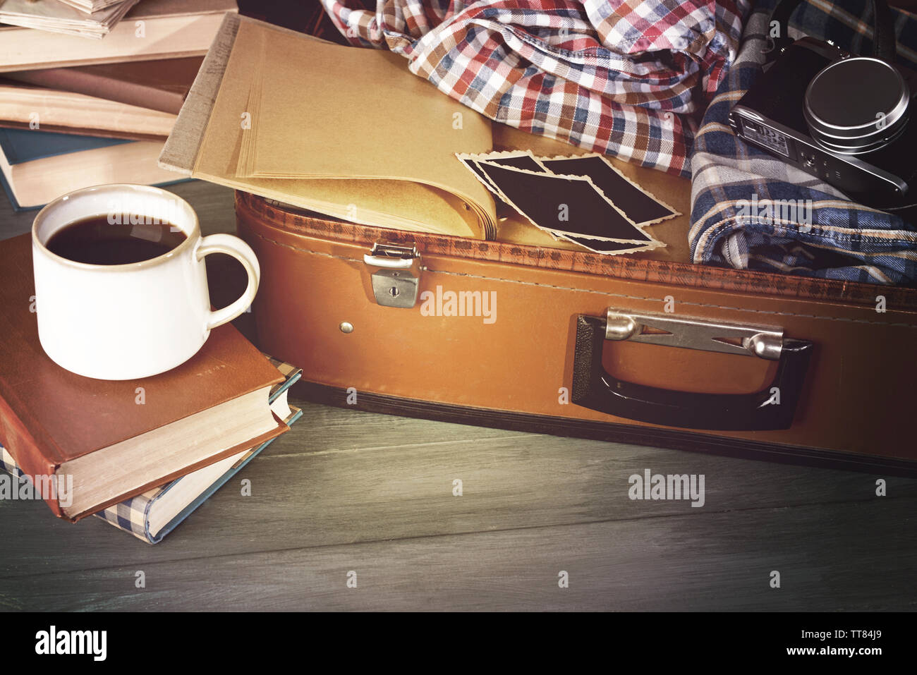 Vintage suitcase open with clothes and books on wooden background Stock ...
