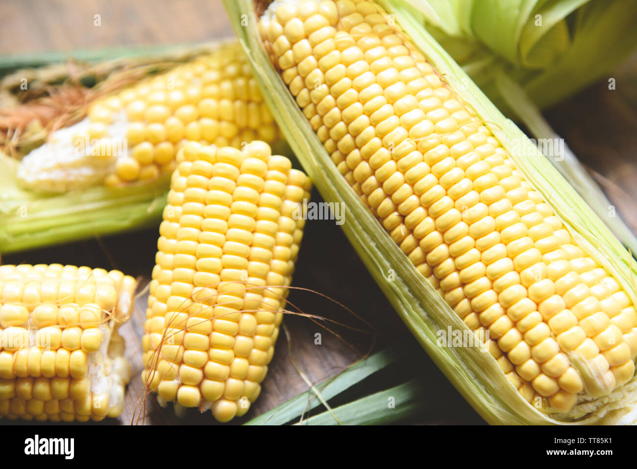Corn on cobs and sweet corn ears on wooden background , close up Stock ...