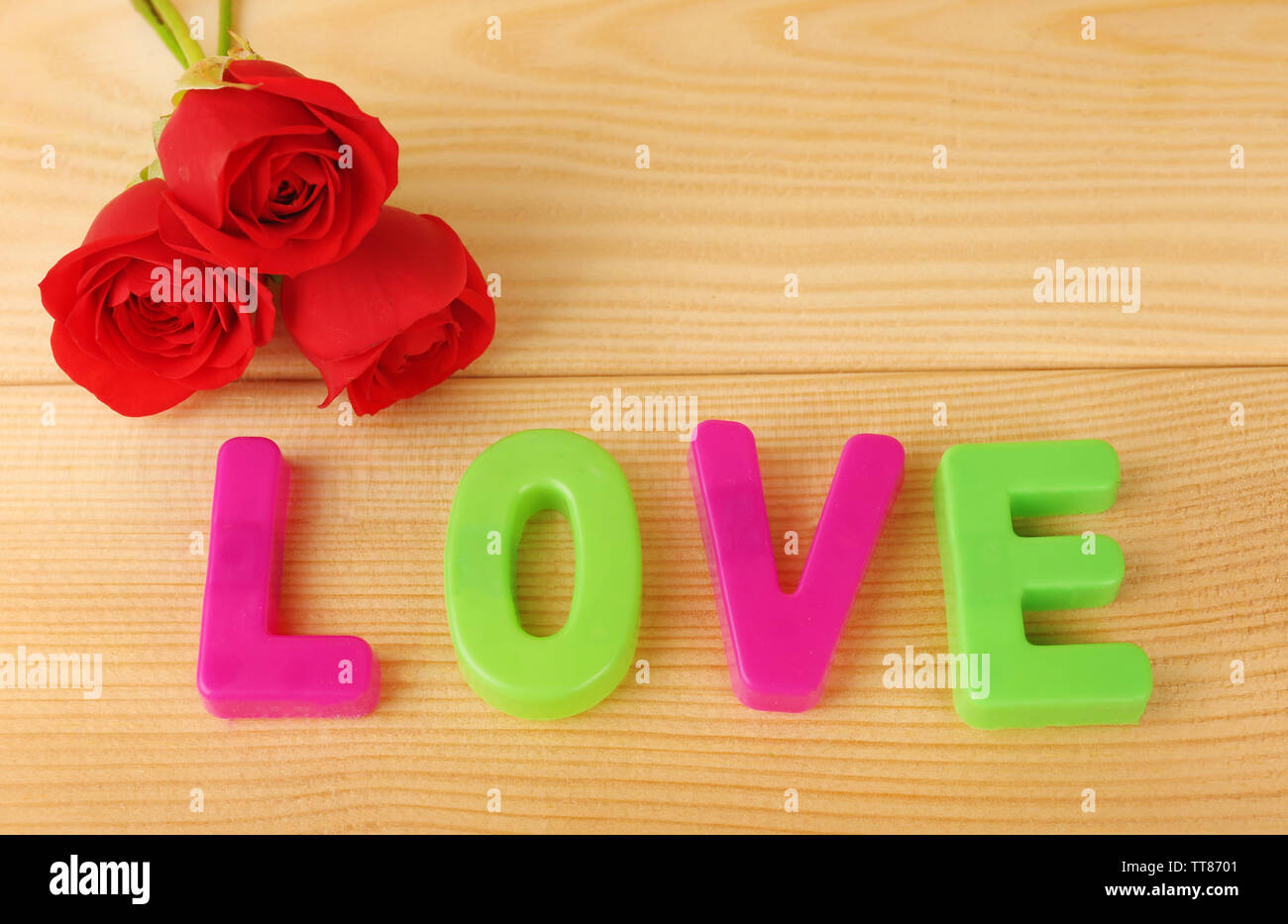Decorative letters forming word LOVE with flowers on wooden background ...