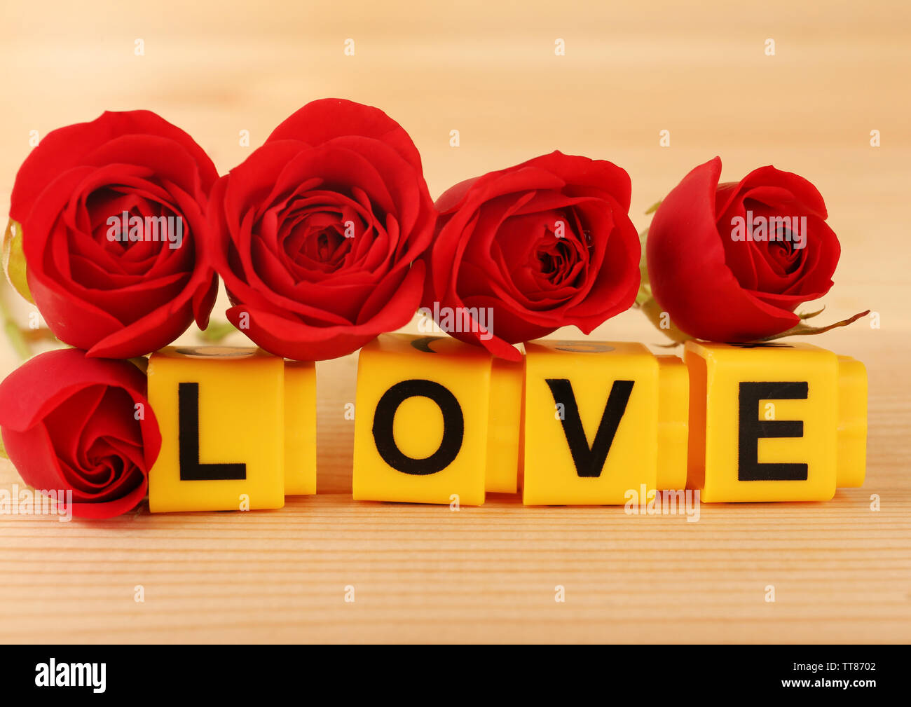 Decorative letters forming word LOVE with flowers on wooden background ...
