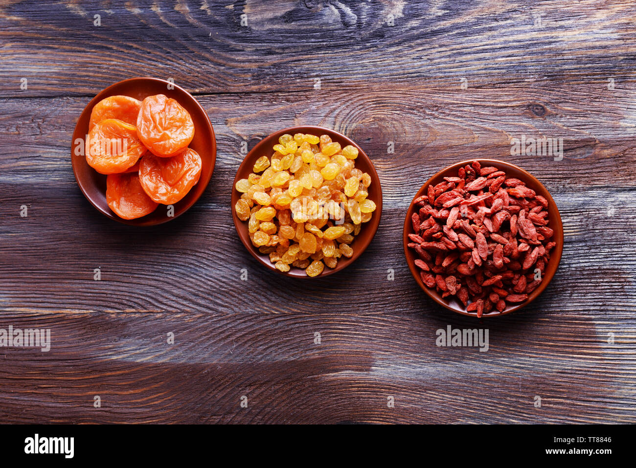 Dried fruits in small plates on rustic wooden table background Stock ...