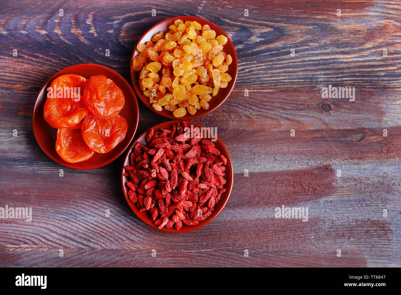 Dried fruits in small plates on rustic wooden table background Stock ...