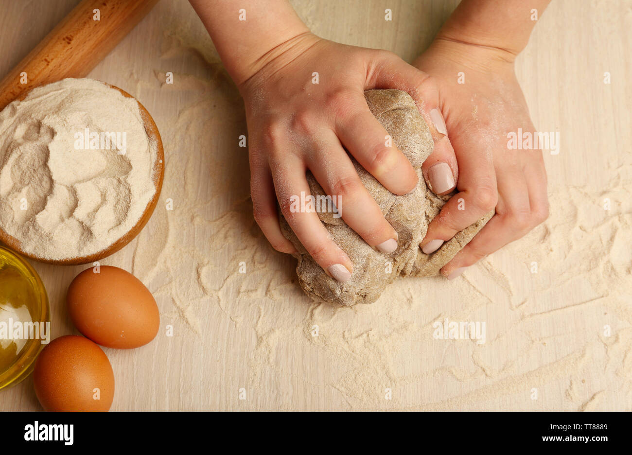 Making dough by female hands on wooden table background Stock Photo - Alamy