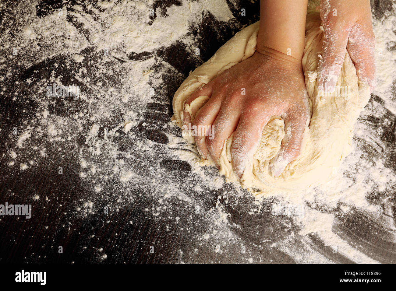 Making dough by female hands on wooden table background Stock Photo - Alamy