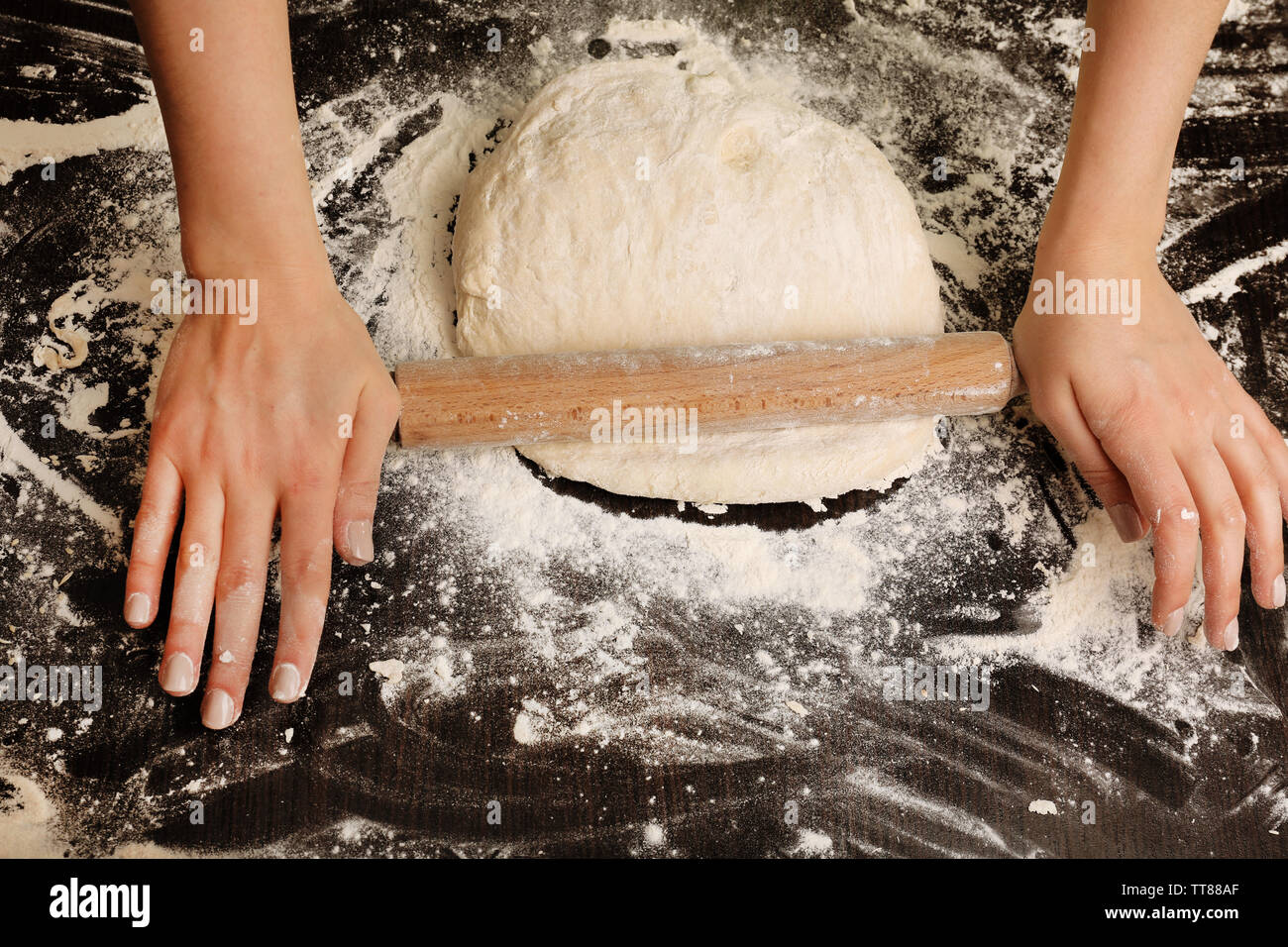 Making dough by female hands on wooden table background Stock Photo - Alamy