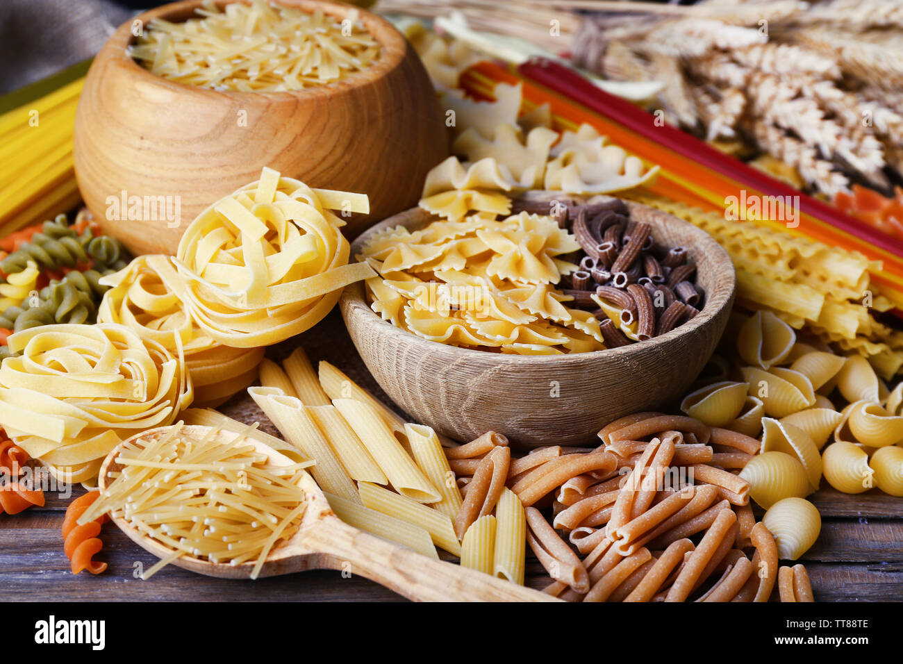Different types of pasta on wooden table background Stock Photo - Alamy