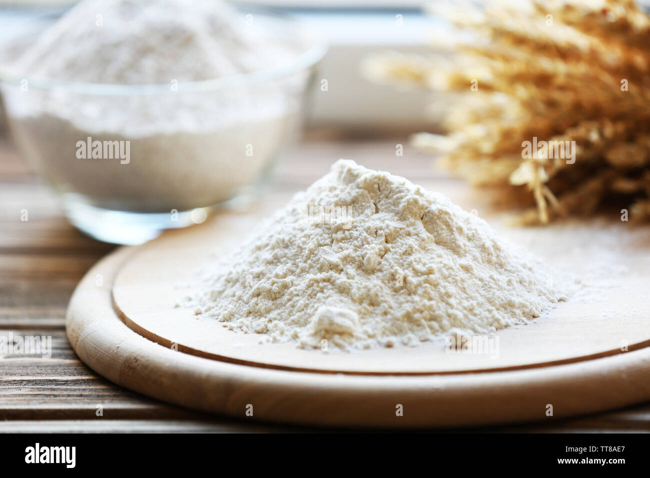 Pile of flour on cutting board with glass bowl, closeup Stock Photo - Alamy