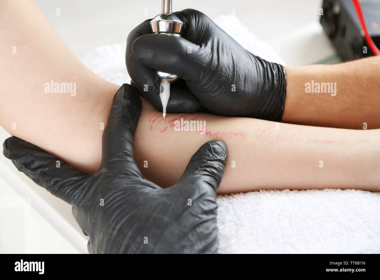 Tattooer showing process of making tattoo, close up Stock Photo - Alamy