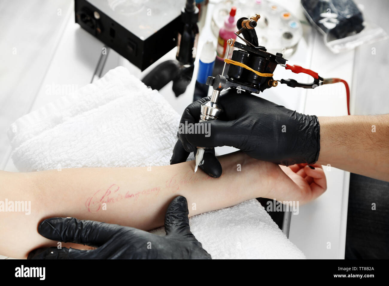 Tattooer showing process of making tattoo, close up Stock Photo - Alamy