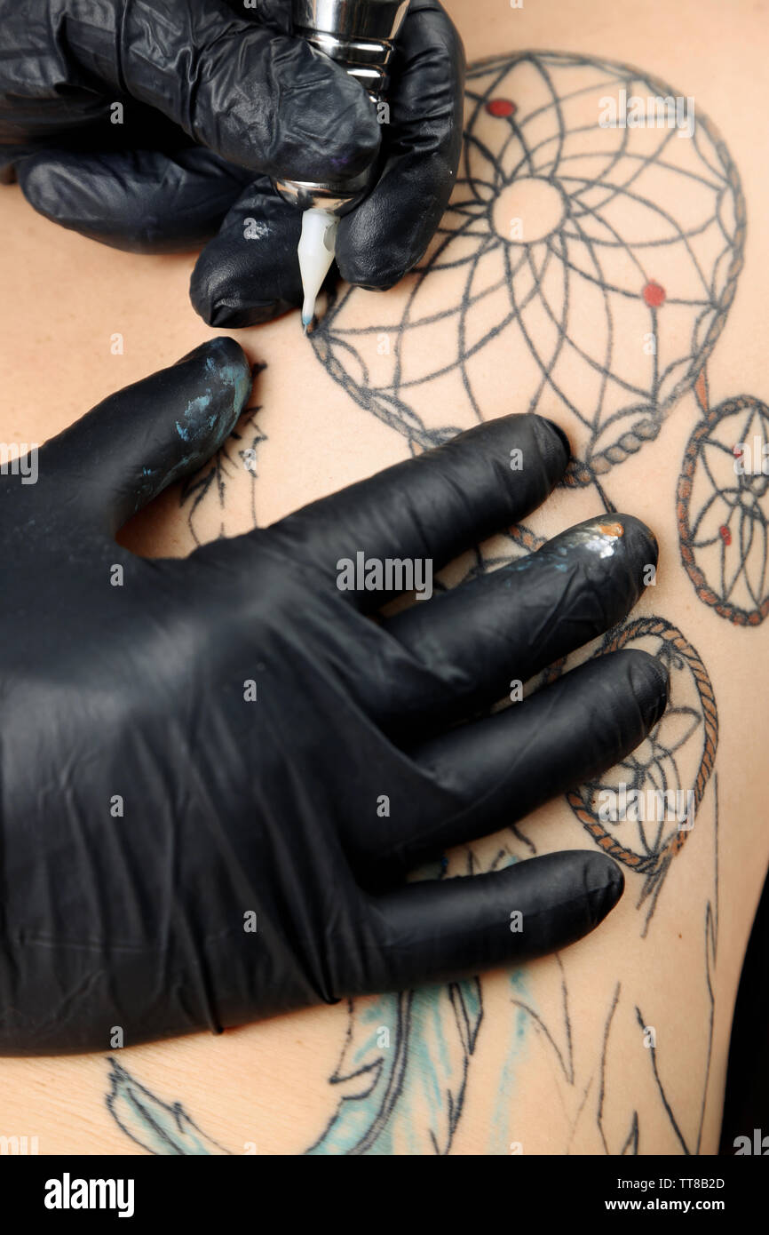 Tattooer showing process of making tattoo, close up Stock Photo - Alamy