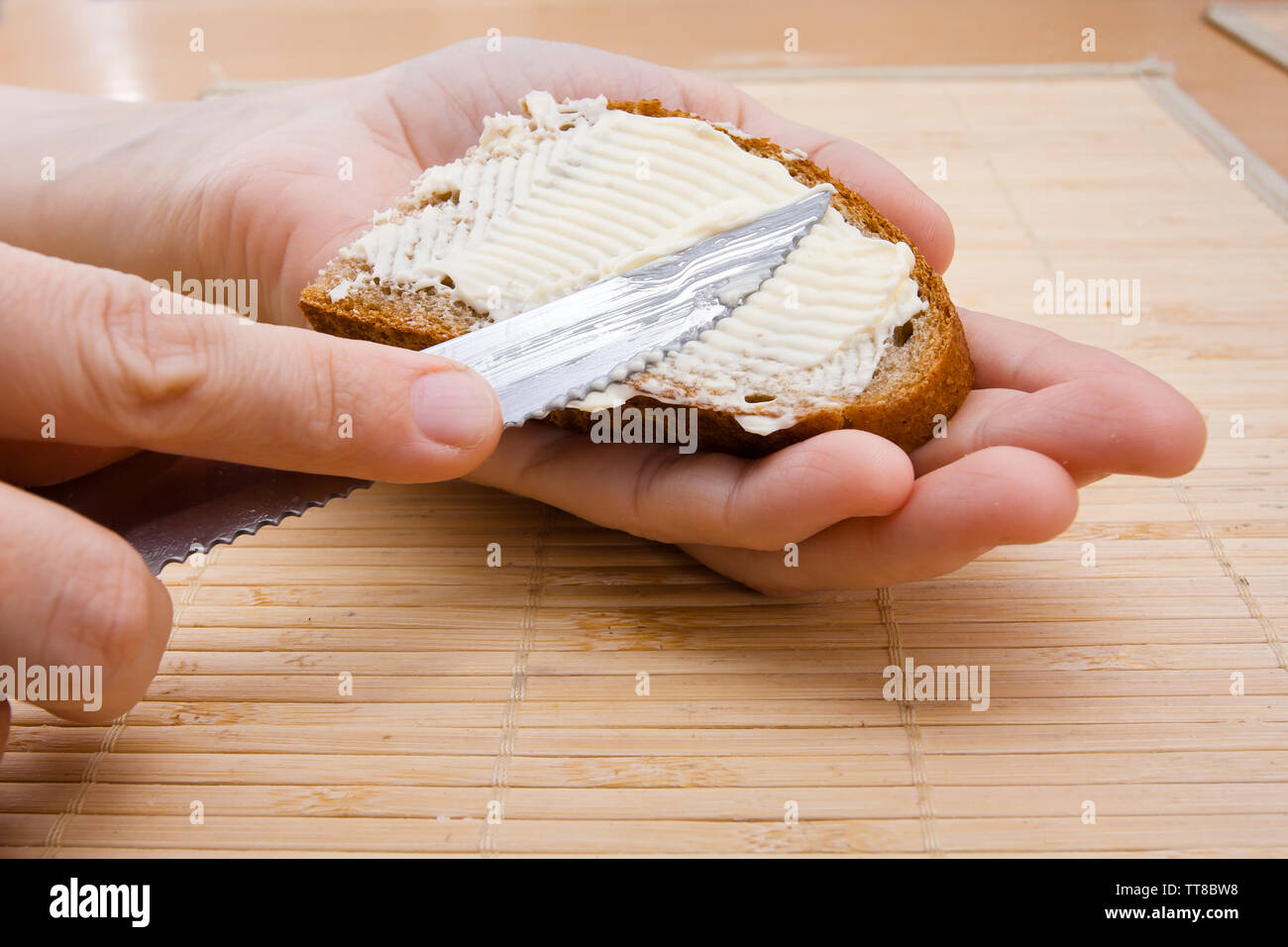 woman hands spreading butter on piece of rye bread, closeup Stock Photo ...