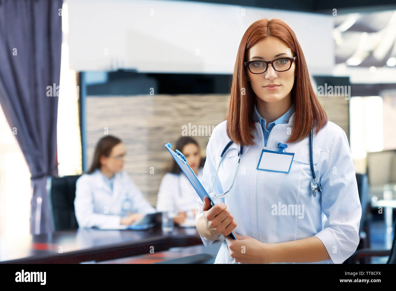 Beautiful young doctor with team in conference room Stock Photo - Alamy