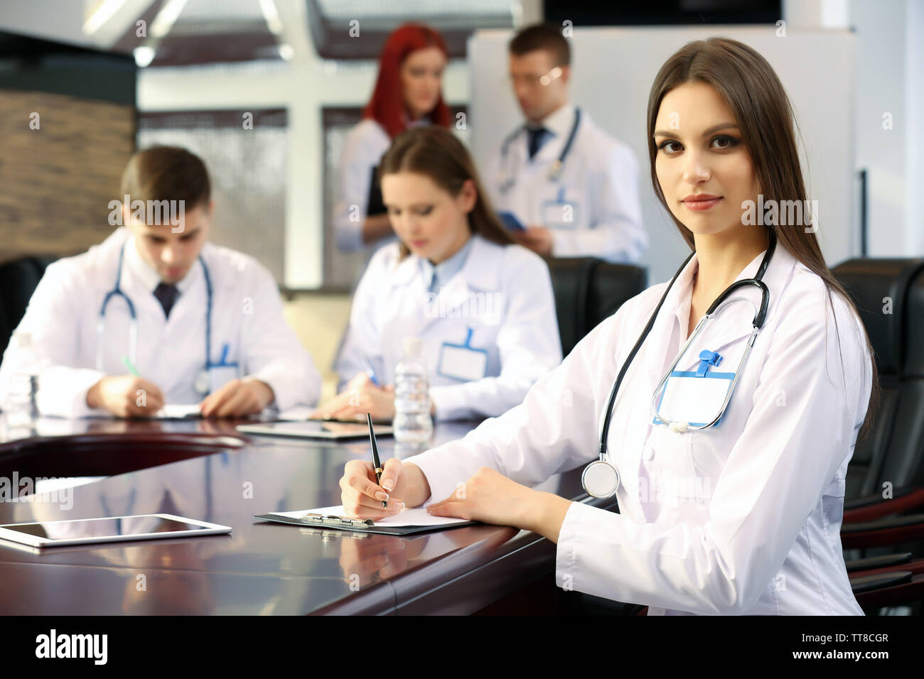 Beautiful young doctor with team in conference room Stock Photo - Alamy