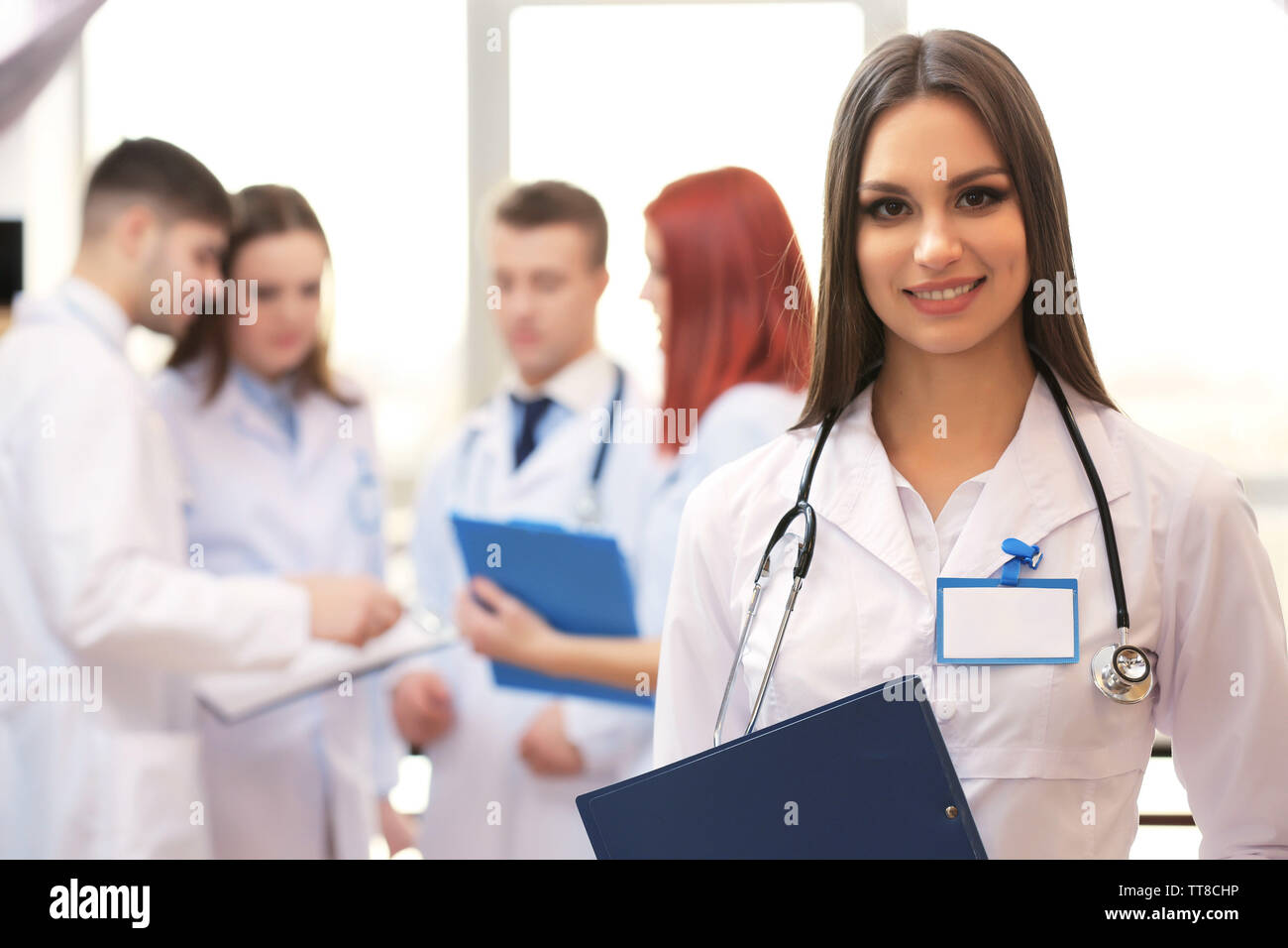 Beautiful young doctor with team in conference room Stock Photo - Alamy