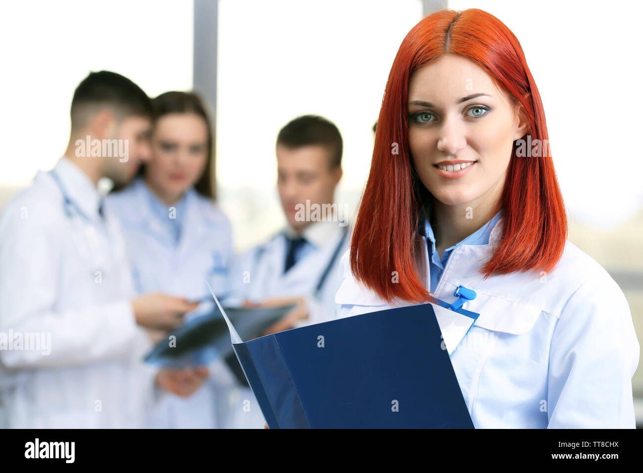 Beautiful young doctor with team in conference room Stock Photo - Alamy