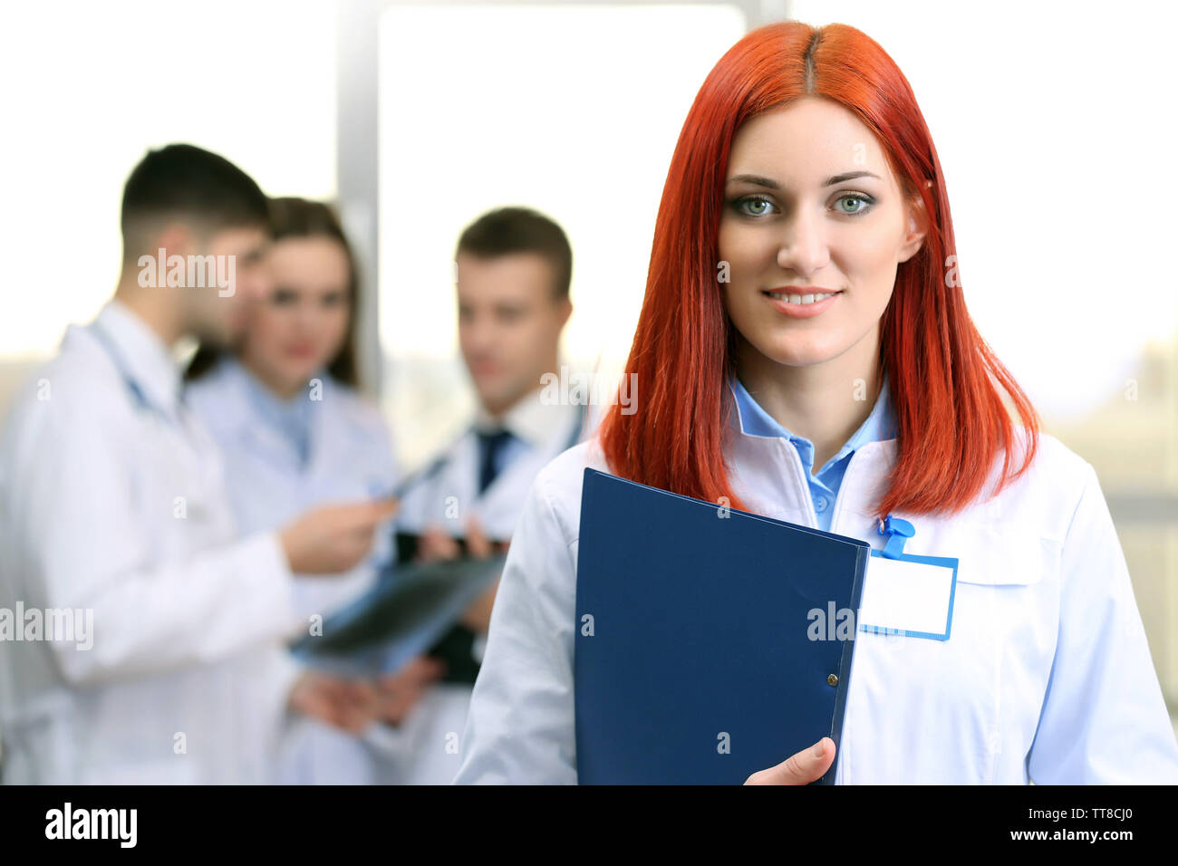 Beautiful young doctor with team in conference room Stock Photo - Alamy