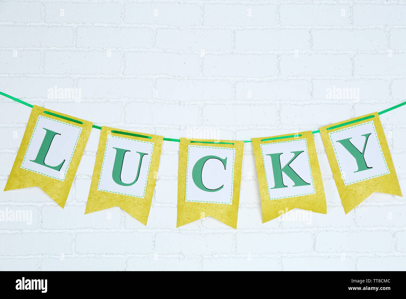 Word Lucky written on paper flags on brick wall background Stock Photo ...