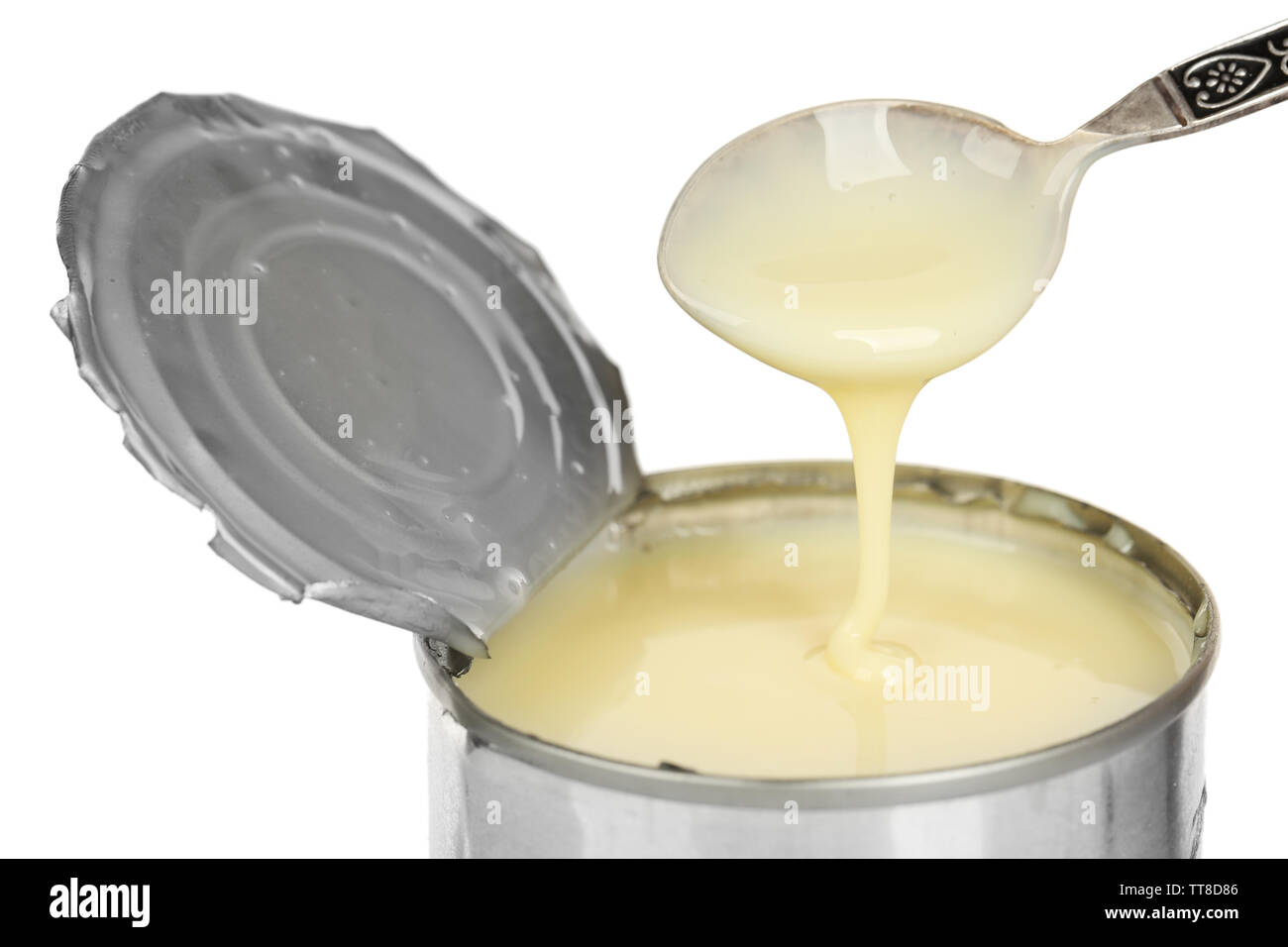 Tin can of condensed milk with spoon isolated on white Stock Photo - Alamy