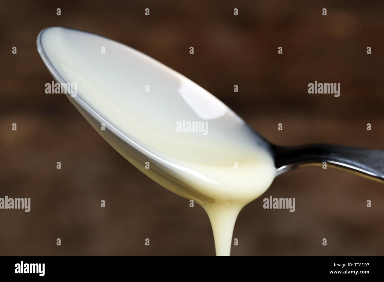 Spoon with condensed milk close up Stock Photo - Alamy