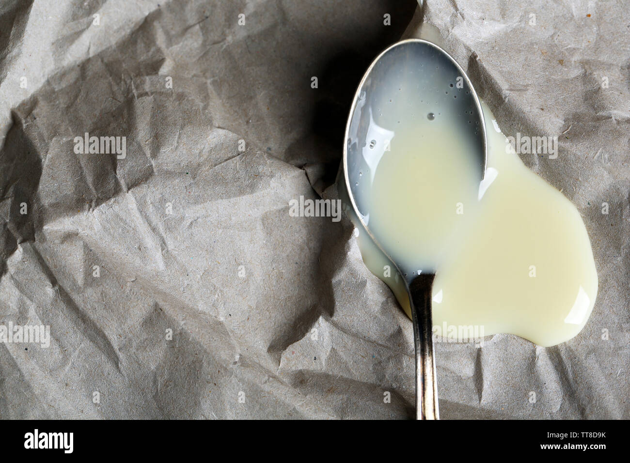 Spoon with condensed milk on paper background Stock Photo - Alamy