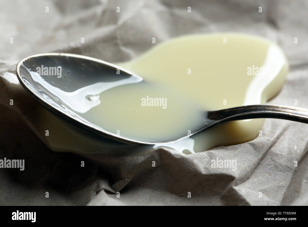 Spoon with condensed milk on paper background Stock Photo - Alamy