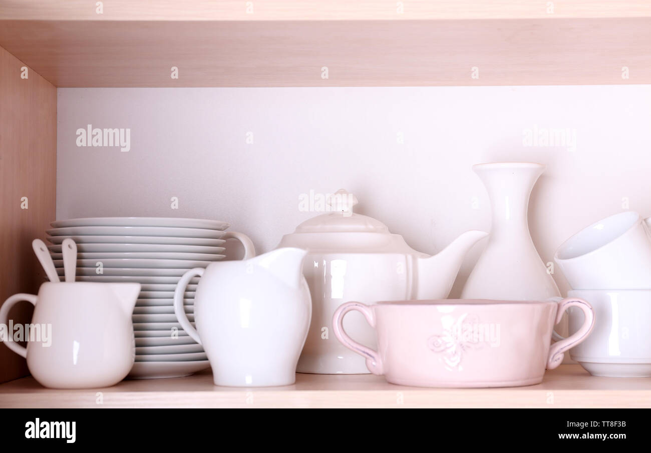 Kitchen utensils and tableware on shelf Stock Photo - Alamy