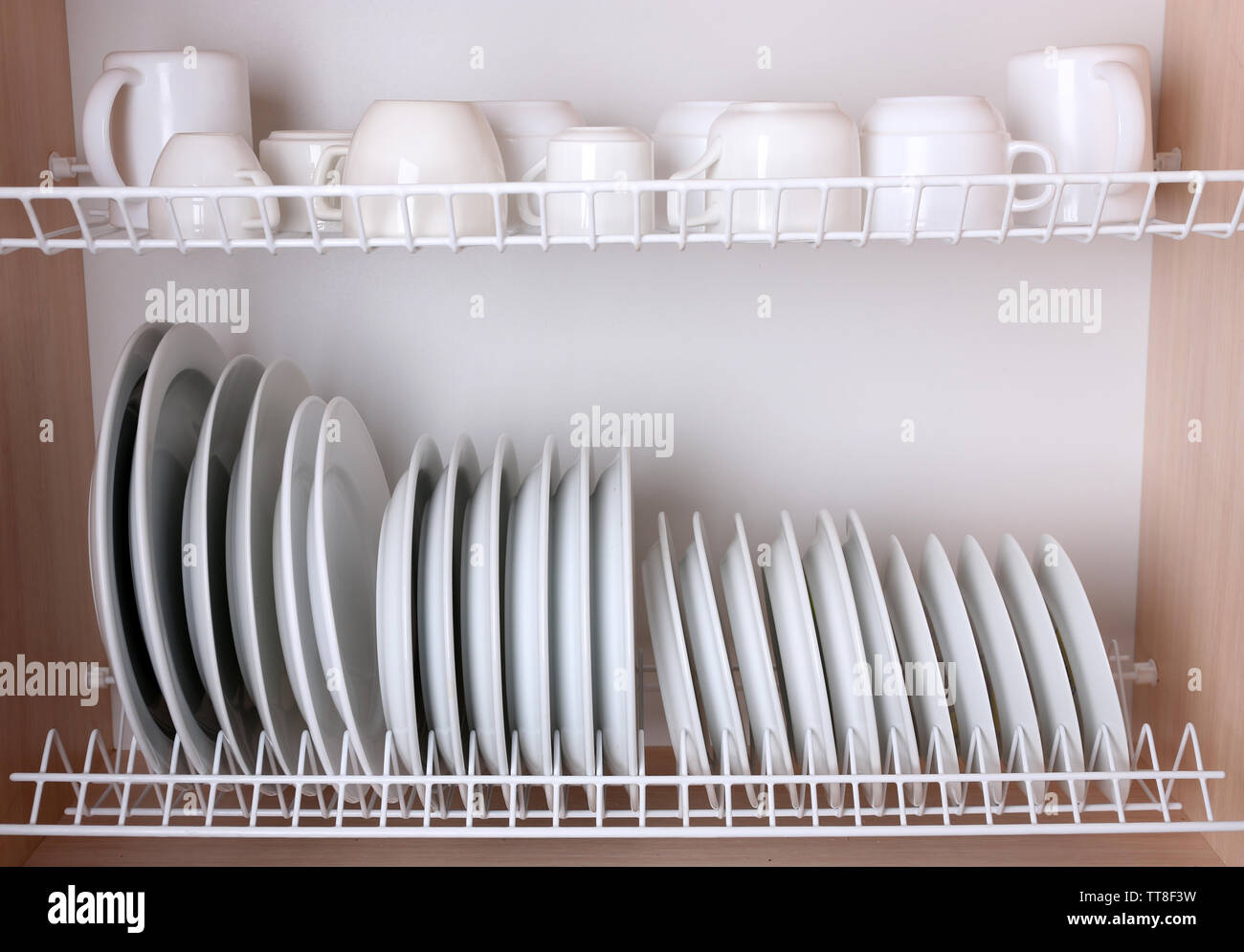 Clean dishes drying on metal dish rack on shelf Stock Photo - Alamy