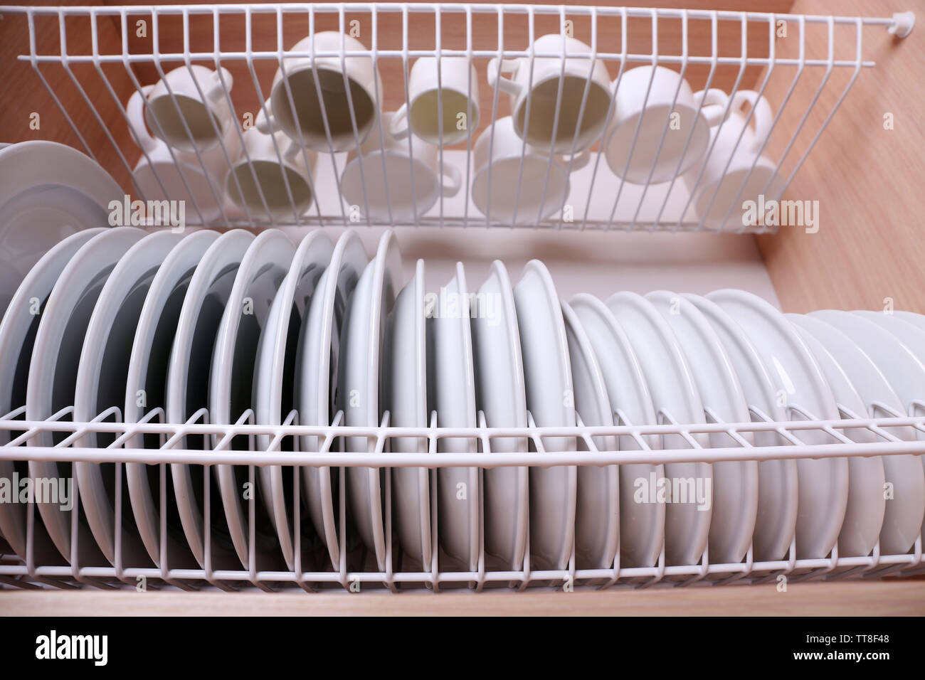 Clean dishes drying on metal dish rack on shelf Stock Photo - Alamy