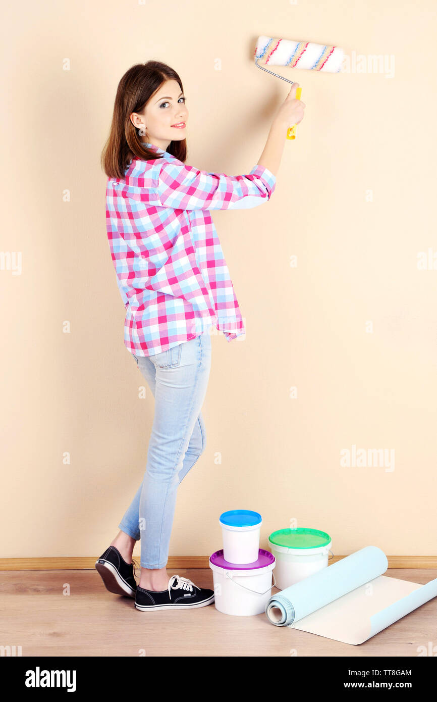Beautiful woman paints wall in room Stock Photo - Alamy